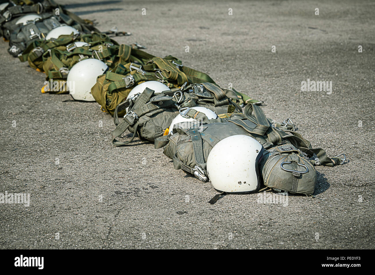 row of T-10 tactical parachute bag with parachute reserve and helmet on ...