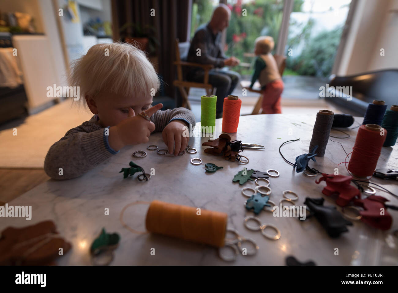 Baby girl playing with sewing thread Stock Photo - Alamy
