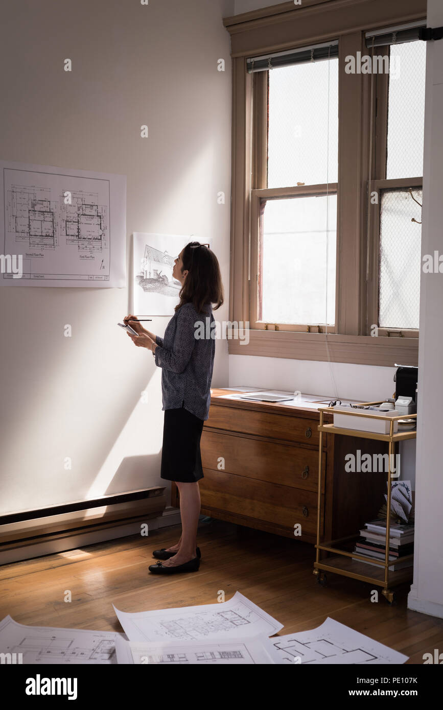 Business woman checking blueprint Stock Photo - Alamy