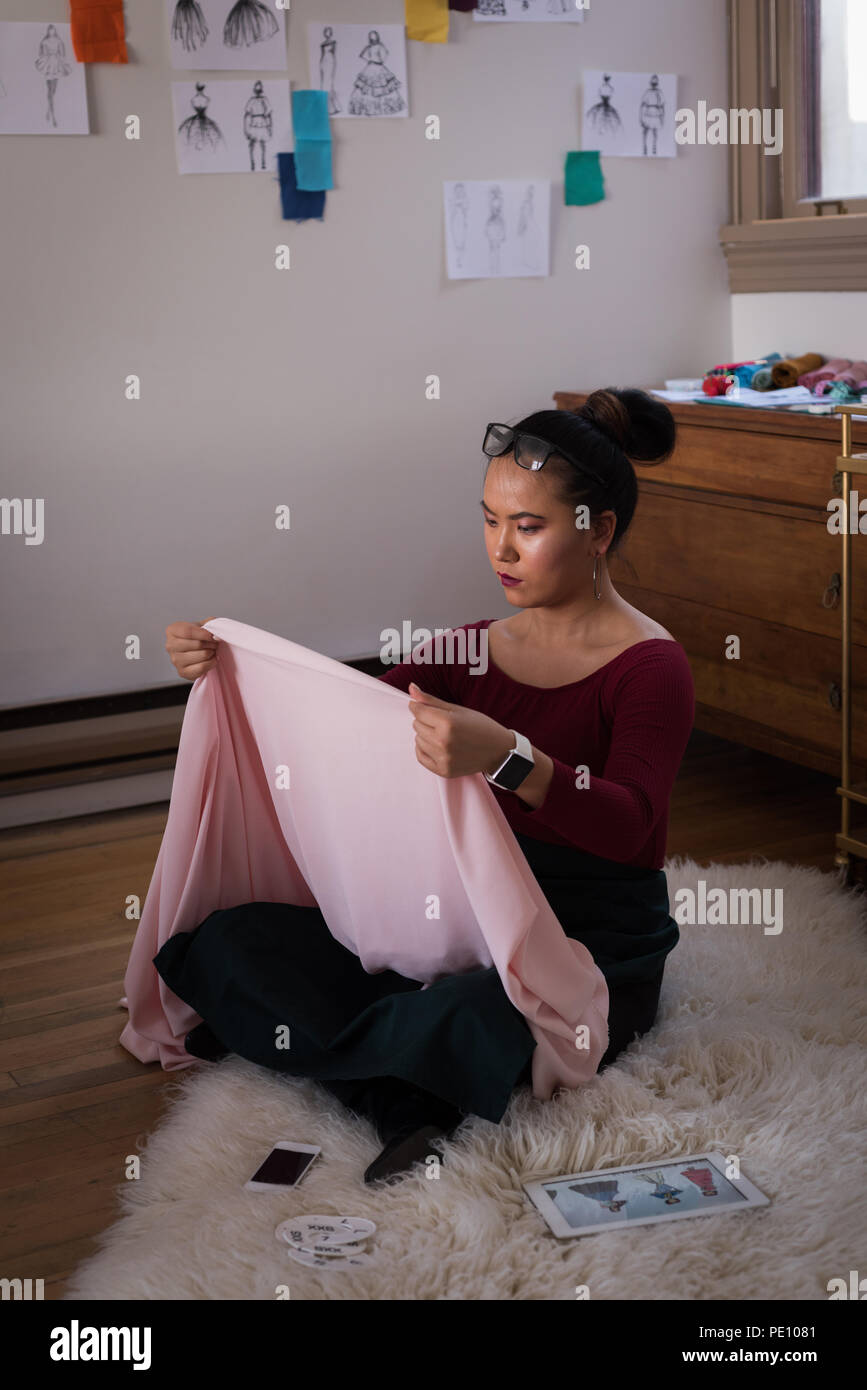 Fashion designer checking fabric Stock Photo - Alamy