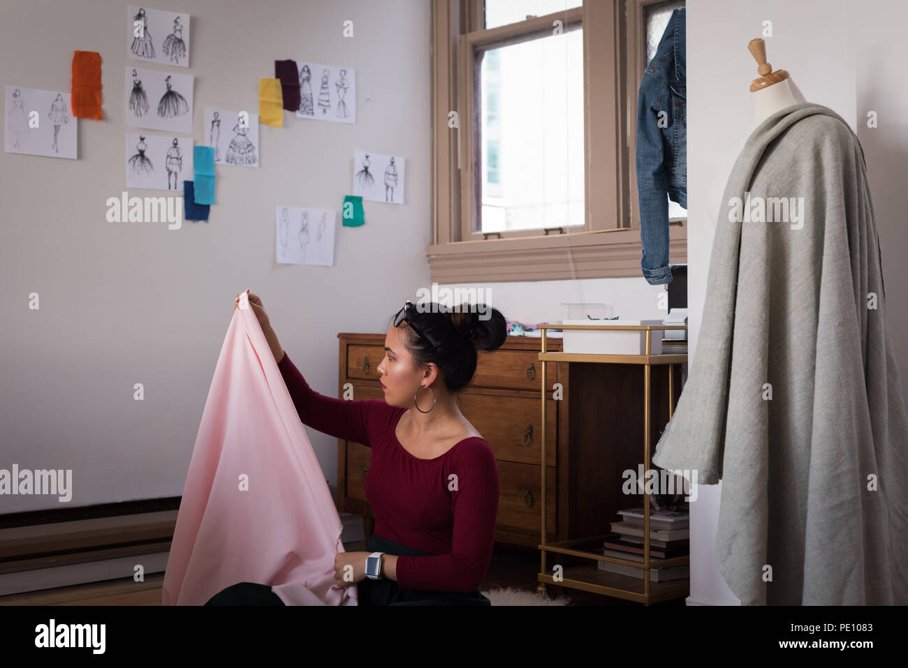 Fashion designer checking fabric Stock Photo - Alamy