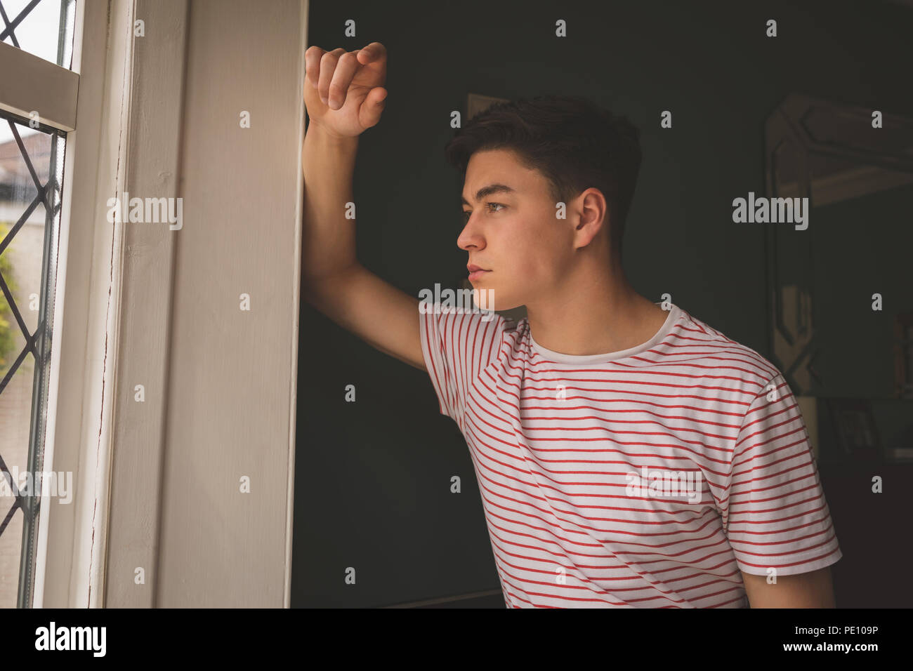 Man looking through window Stock Photo - Alamy