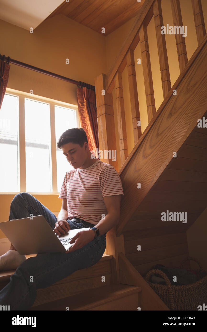 Man using laptop on staircase Stock Photo - Alamy