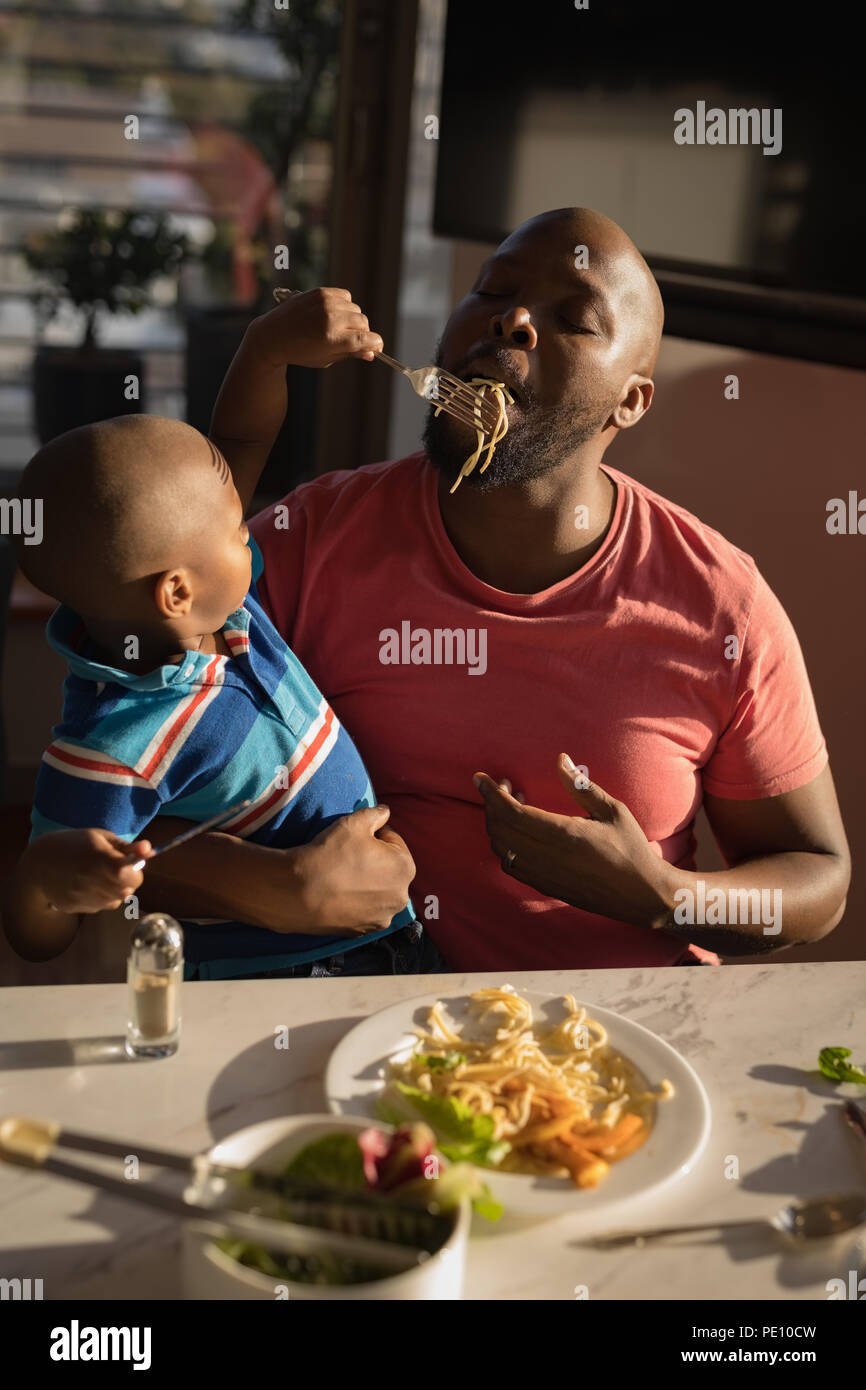 Son feeding his father breakfast Stock Photo - Alamy