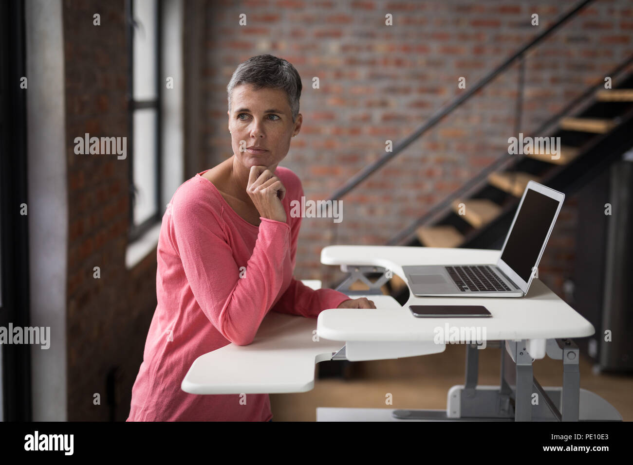 Female executive using laptop in office Stock Photo - Alamy