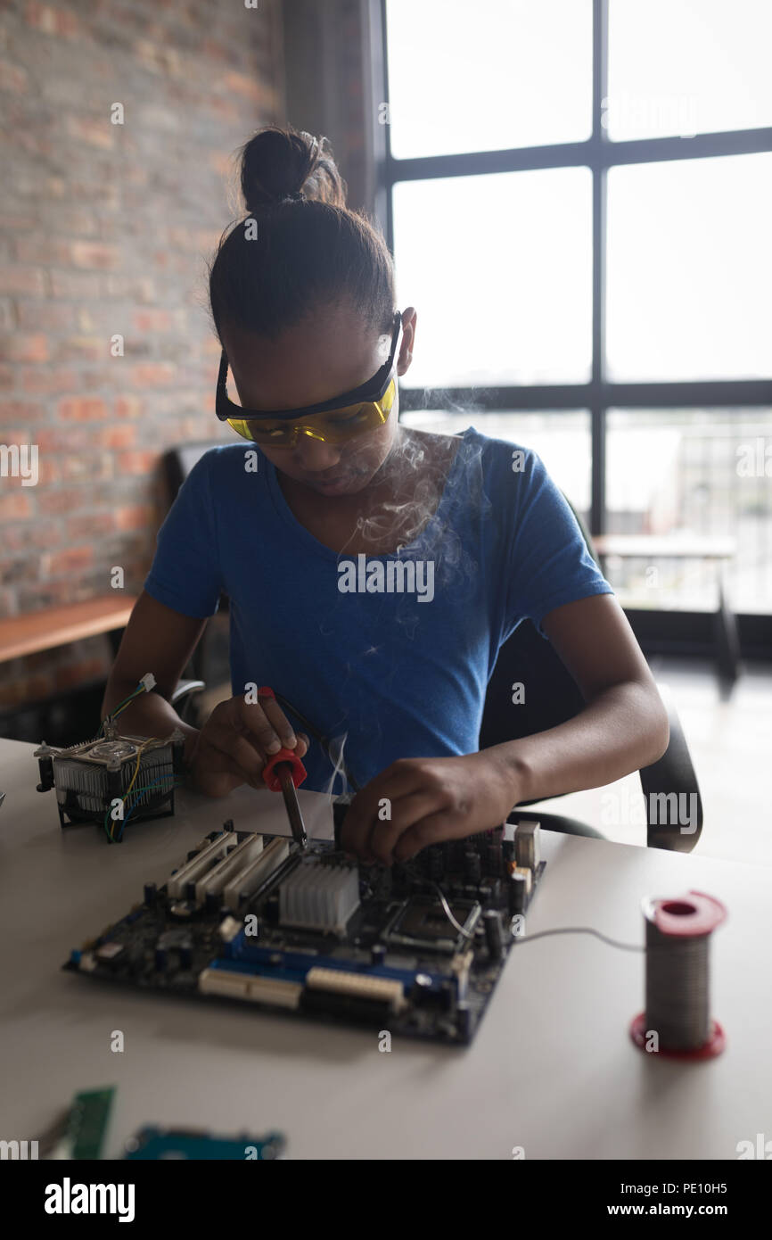 Girl soldering a circuit board at desk Stock Photo - Alamy