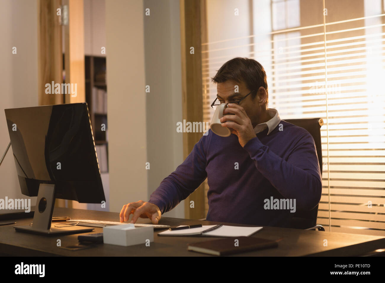 Businessman sitting desk drinking coffee hi-res stock photography and ...