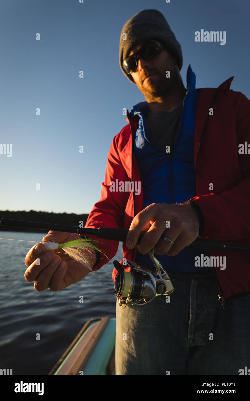 Man tying bait in fishing rod Stock Photo - Alamy