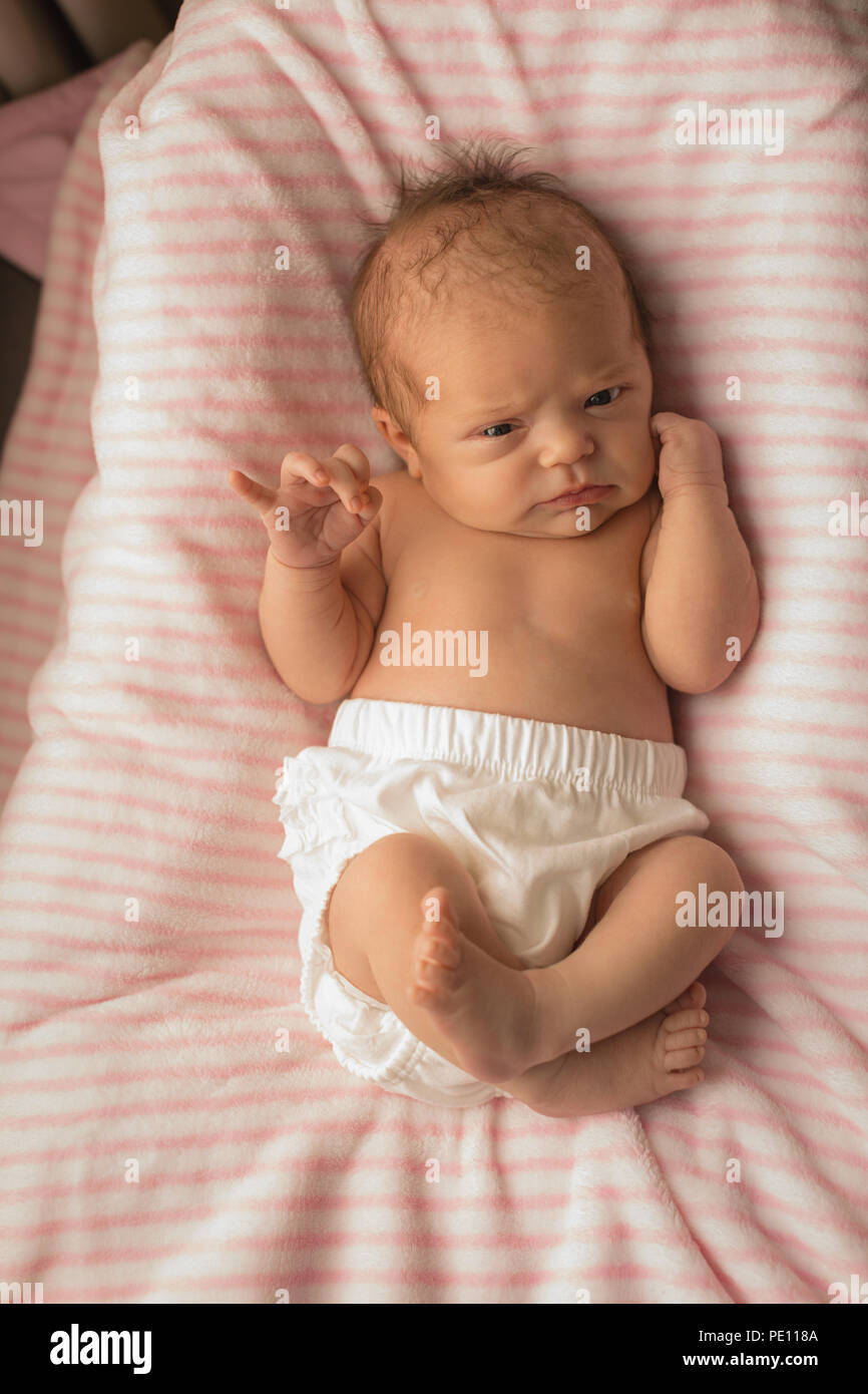 Newborn baby relaxing on baby bed Stock Photo - Alamy