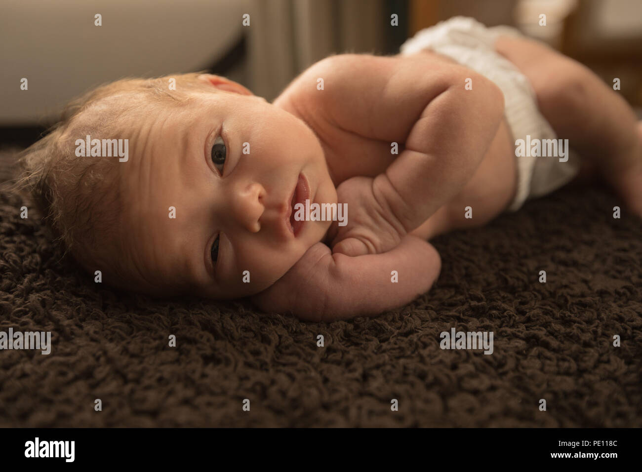 Newborn baby relaxing on baby bed Stock Photo - Alamy