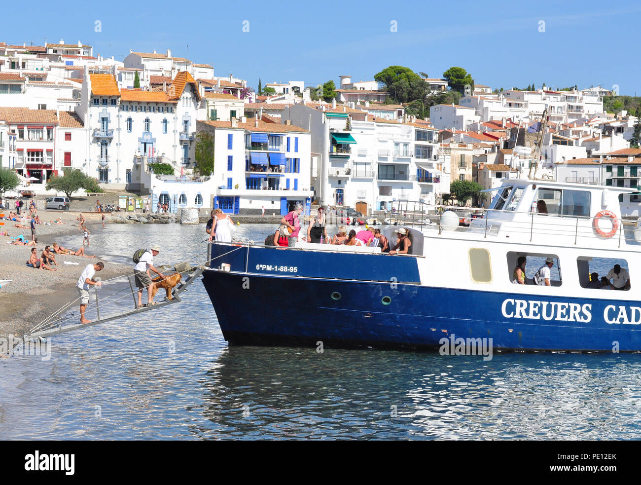 Tourists are boarding to the boat in Cadaques bay, Spain Stock Photo ...