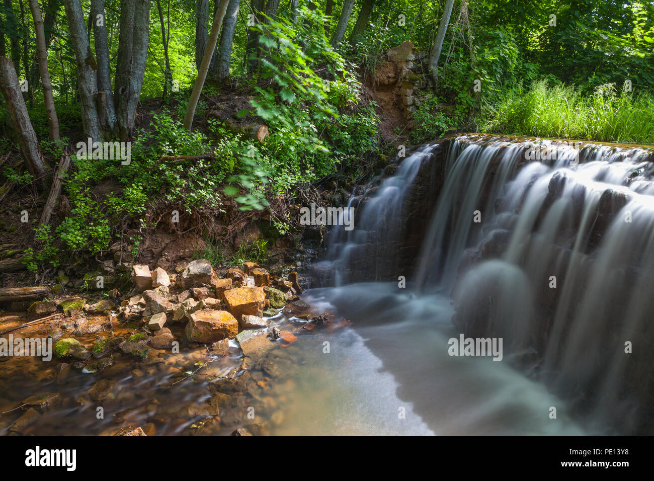 Waterfalls of Ieriku nature park at old watermill in the forest. It's a ...