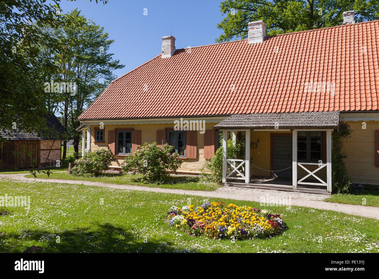 Traditional wooden vintage house yard with blooming greenery. Northern ...