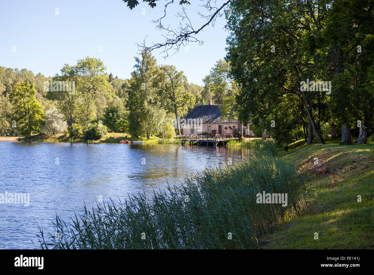 Beautiful old vintage house on the bank of the lake. Trees at the ...