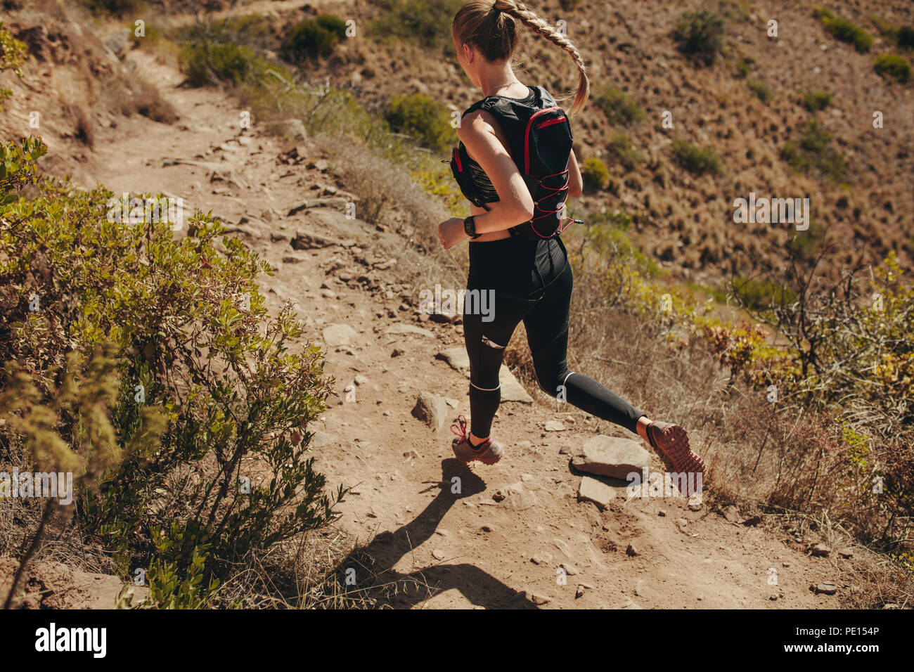 Top view of young woman running on mountain trail. Woman running on ...