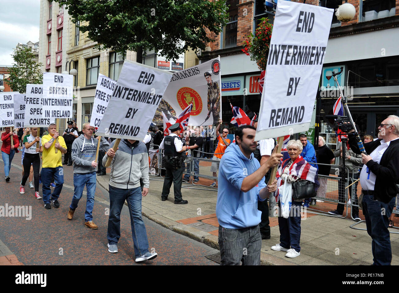 Protesters walk past a loyalist banner on an anti-internment march in ...