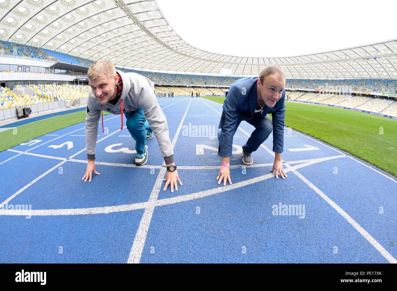 Editorial use only. Two men taking ready to start position on a track ...