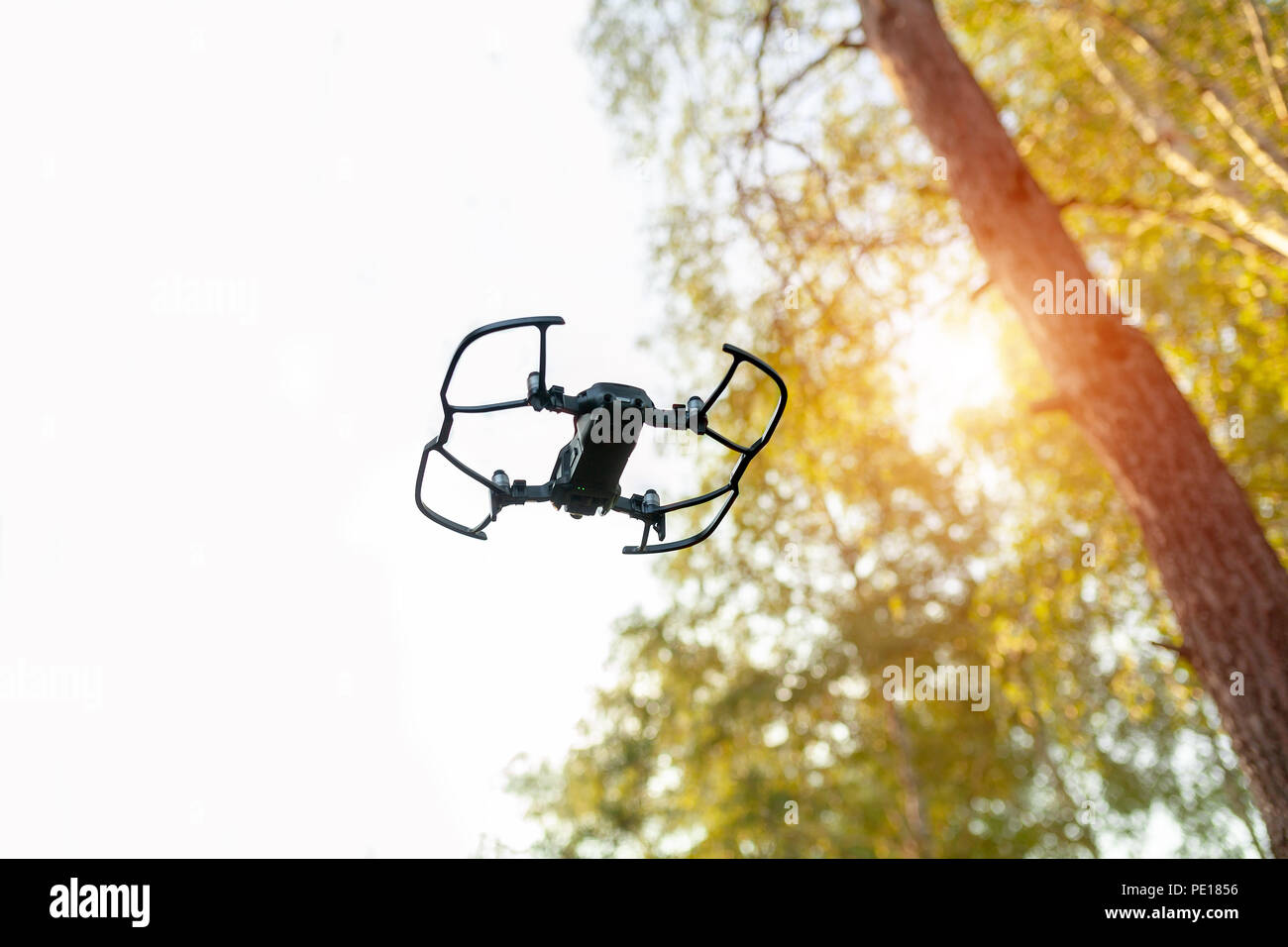 Small Smart Drone quadrocopter Flying on White Sky and Green trees ...