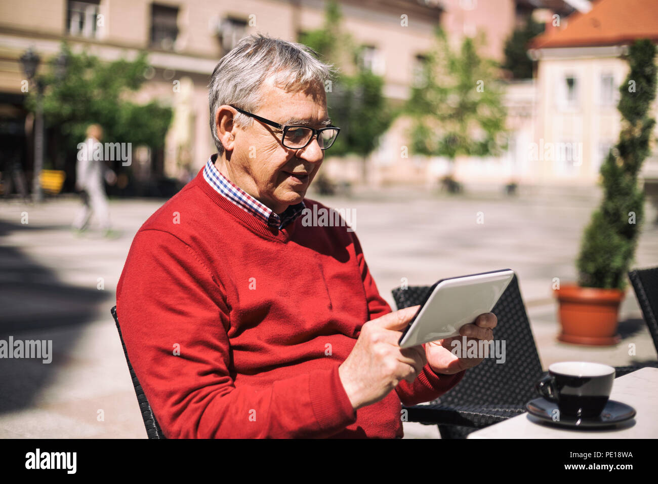 Senior man using digital tablet while drinking coffee at the bar.Image ...