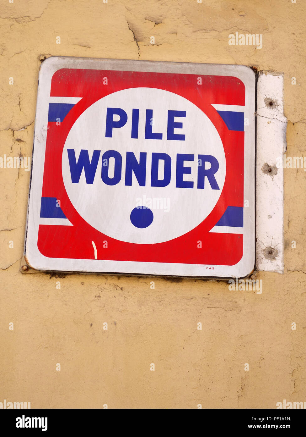 Metal sign on a shop exterior wall advertising Pile Wonder products as ...