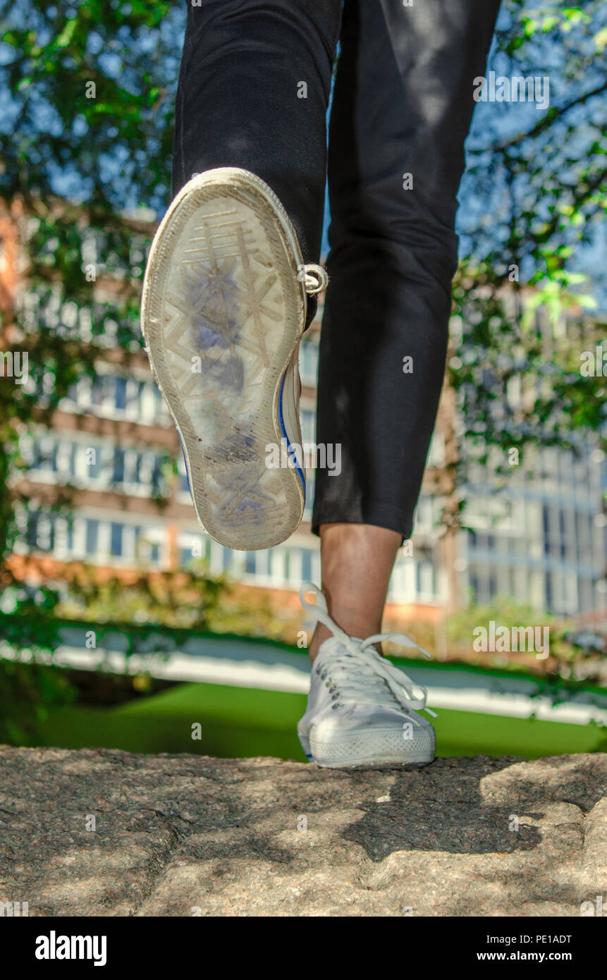 female foot in white sneakers takes a step forward Stock Photo - Alamy
