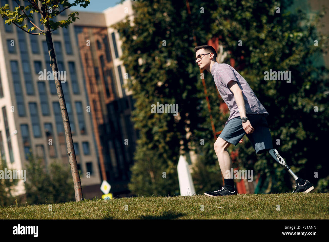 Disabled young man with foot prosthesis walks in park Stock Photo - Alamy