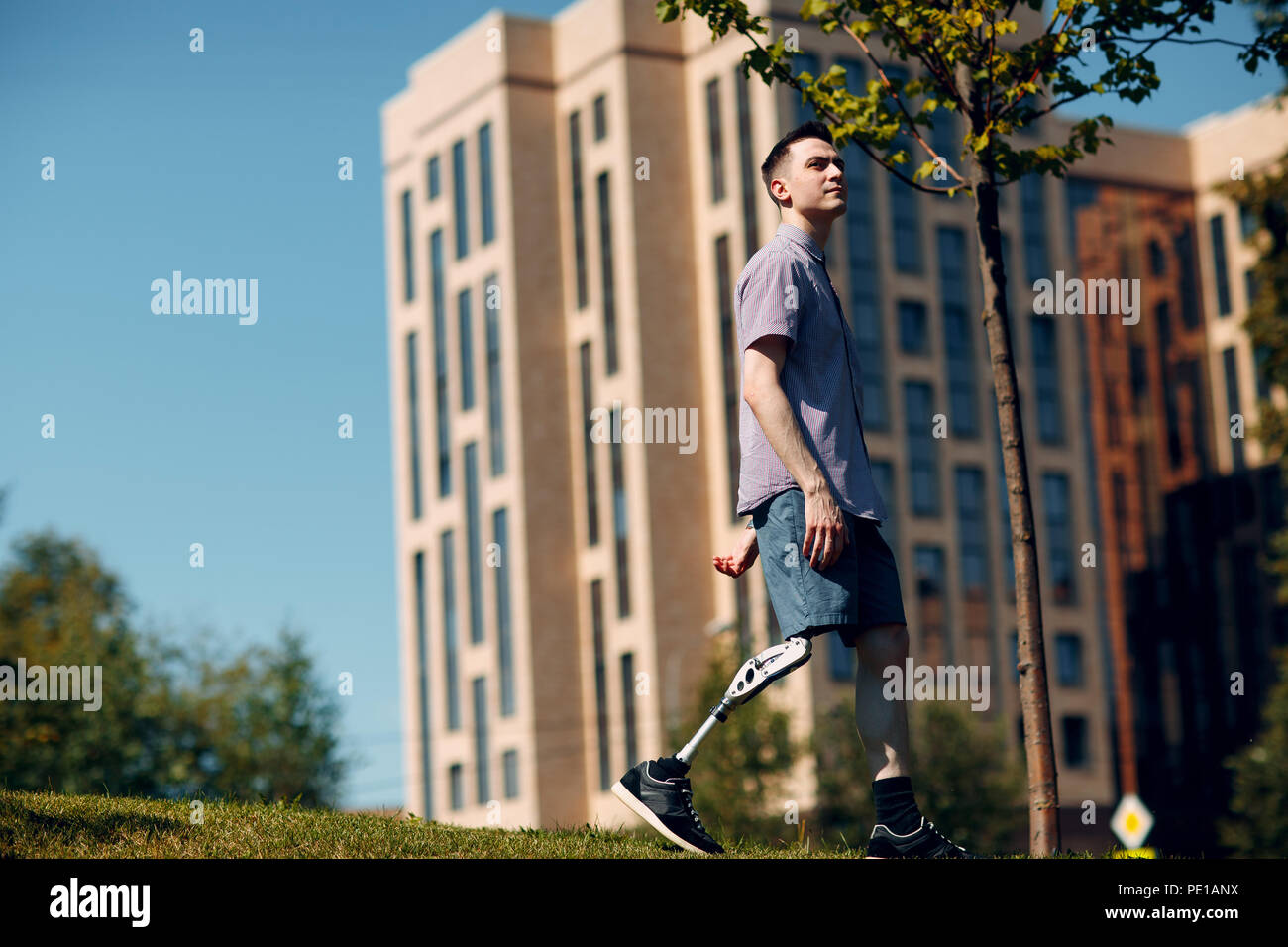 Disabled young man with foot prosthesis walks in park Stock Photo - Alamy