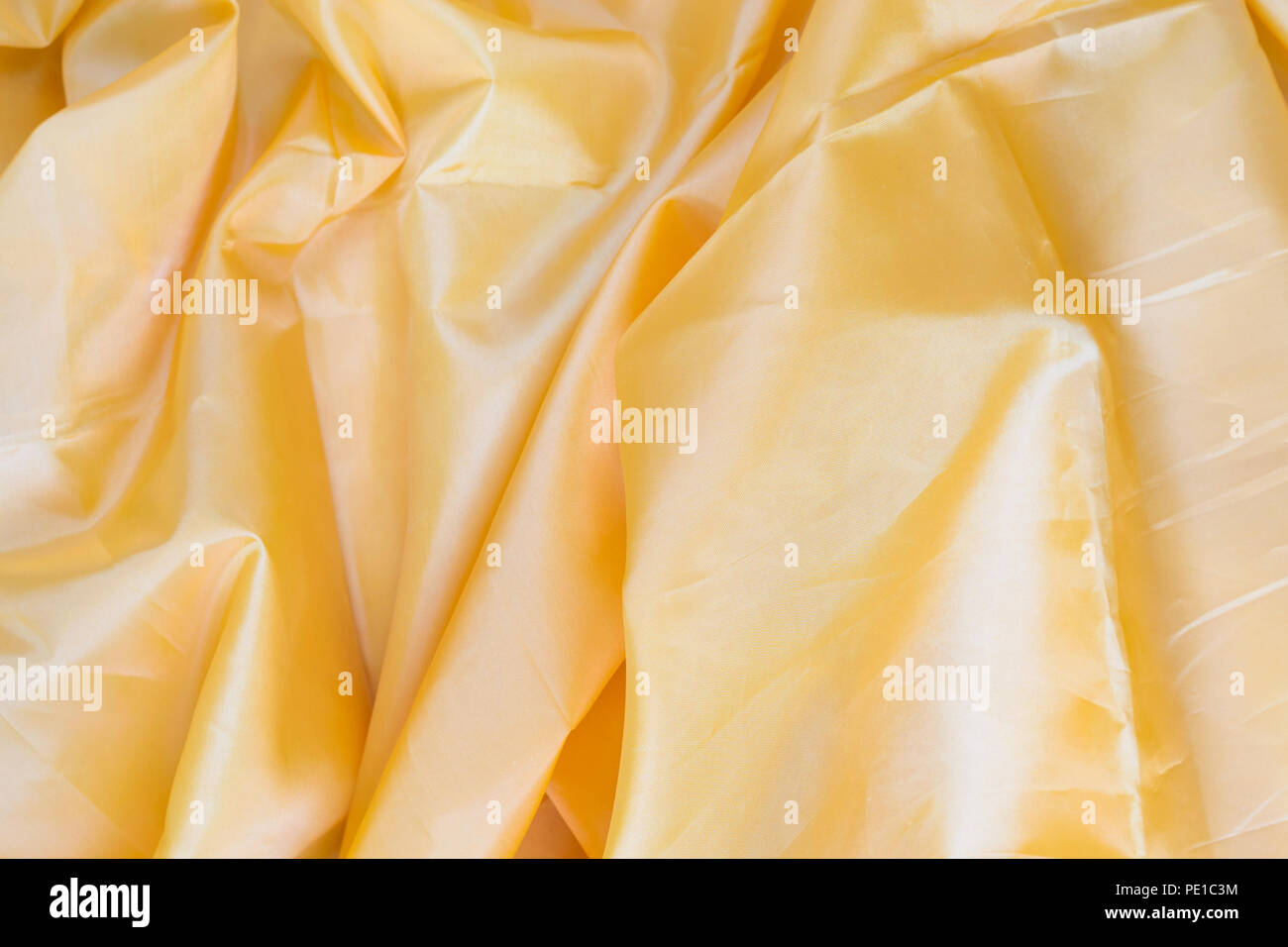 Yellow Synthetic Lining Fabric with Folds. Crumpled Sheet or Clothes ...