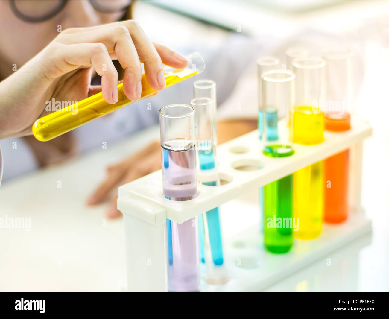 Lab woman pouring yellow hi-res stock photography and images - Alamy