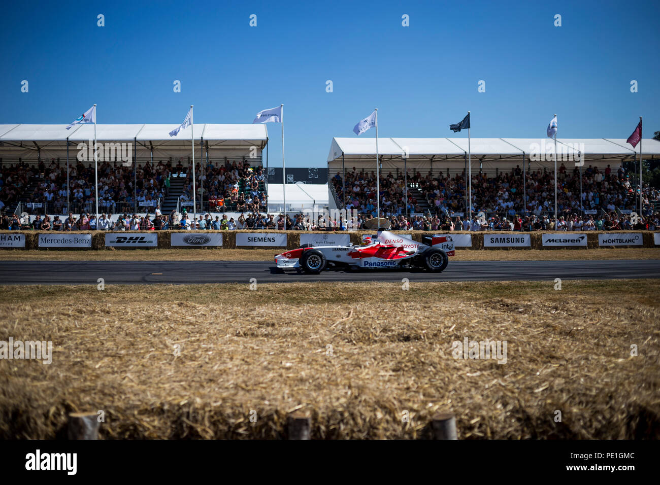 A McLaren Formula One car speeds past a grandstand on the hillclimb at ...
