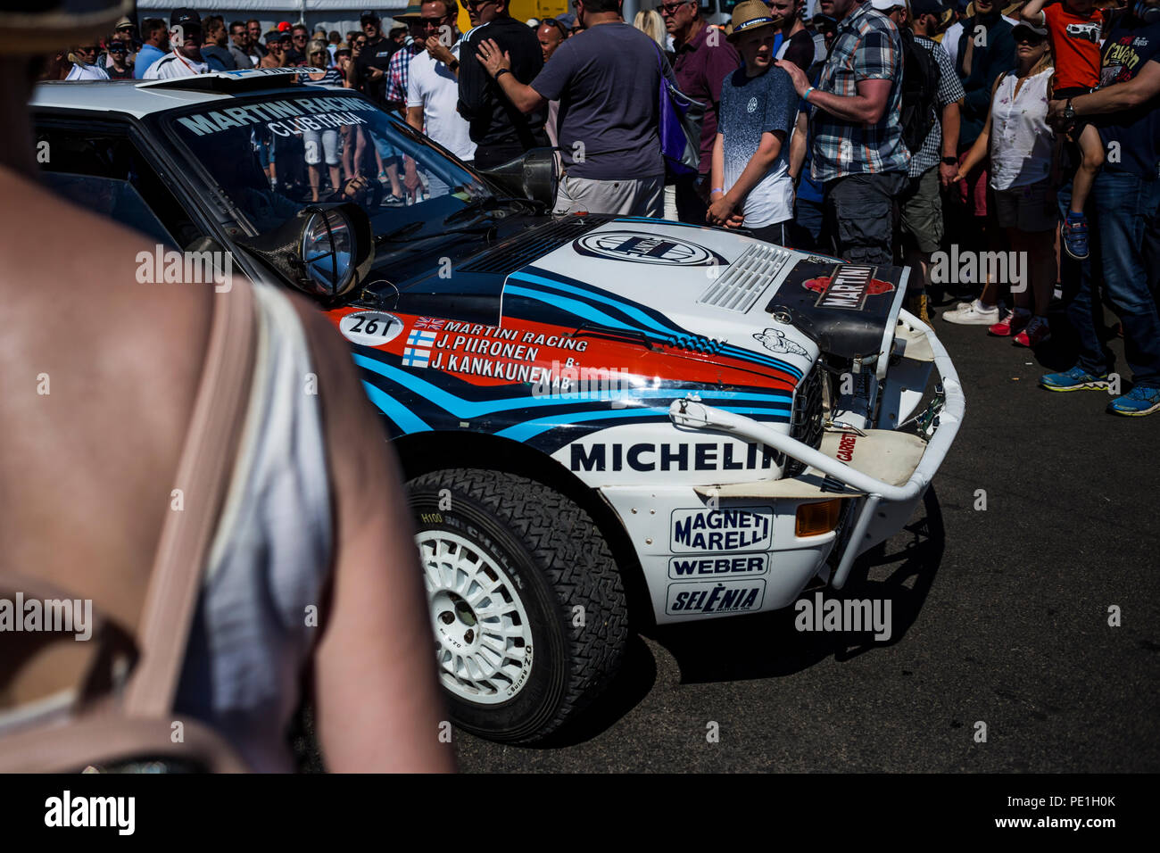 A rally car returning to the paddock through a crowd at the Goodwood ...