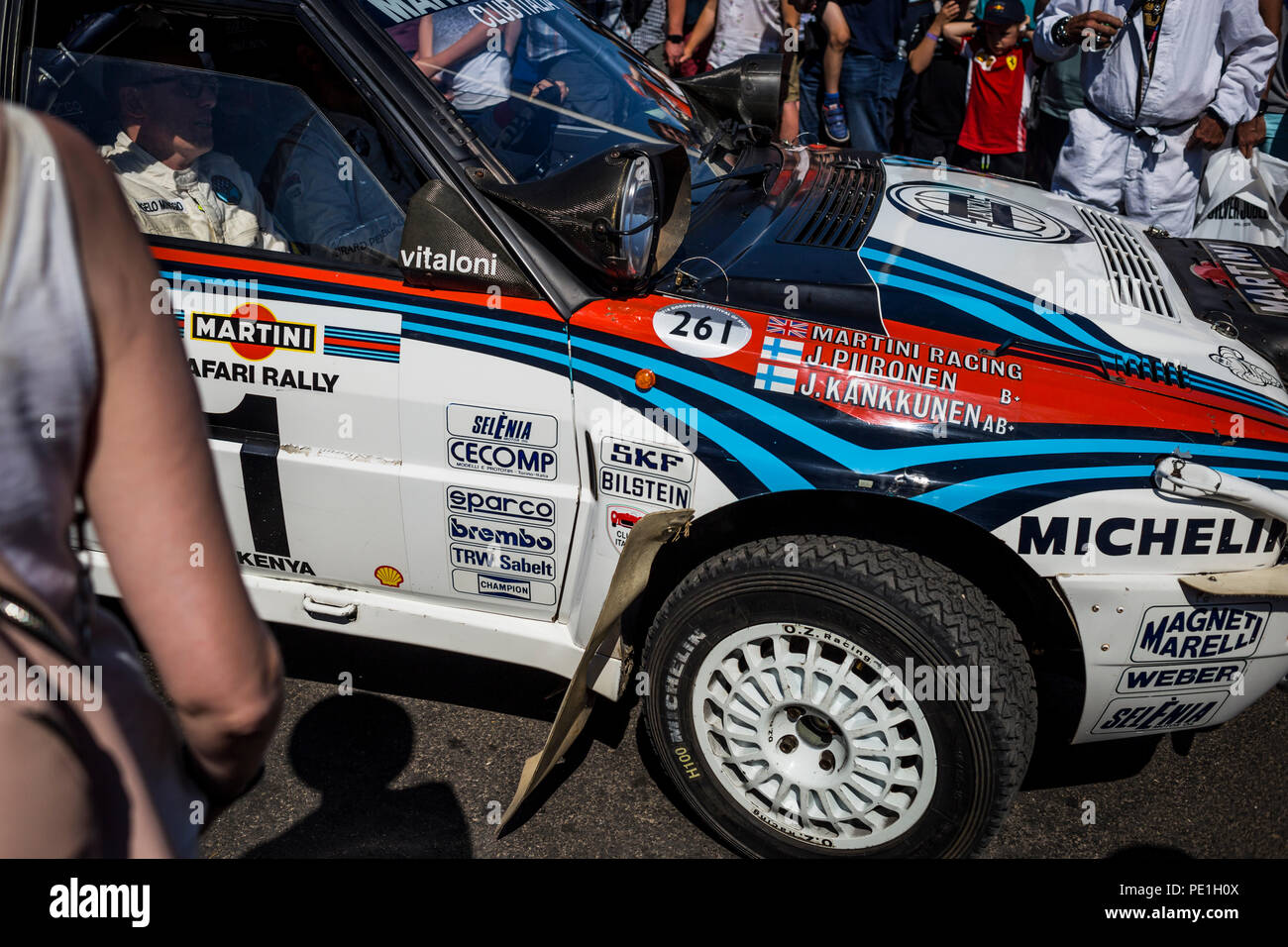 A rally car returning to the paddock through a crowd at the Goodwood ...