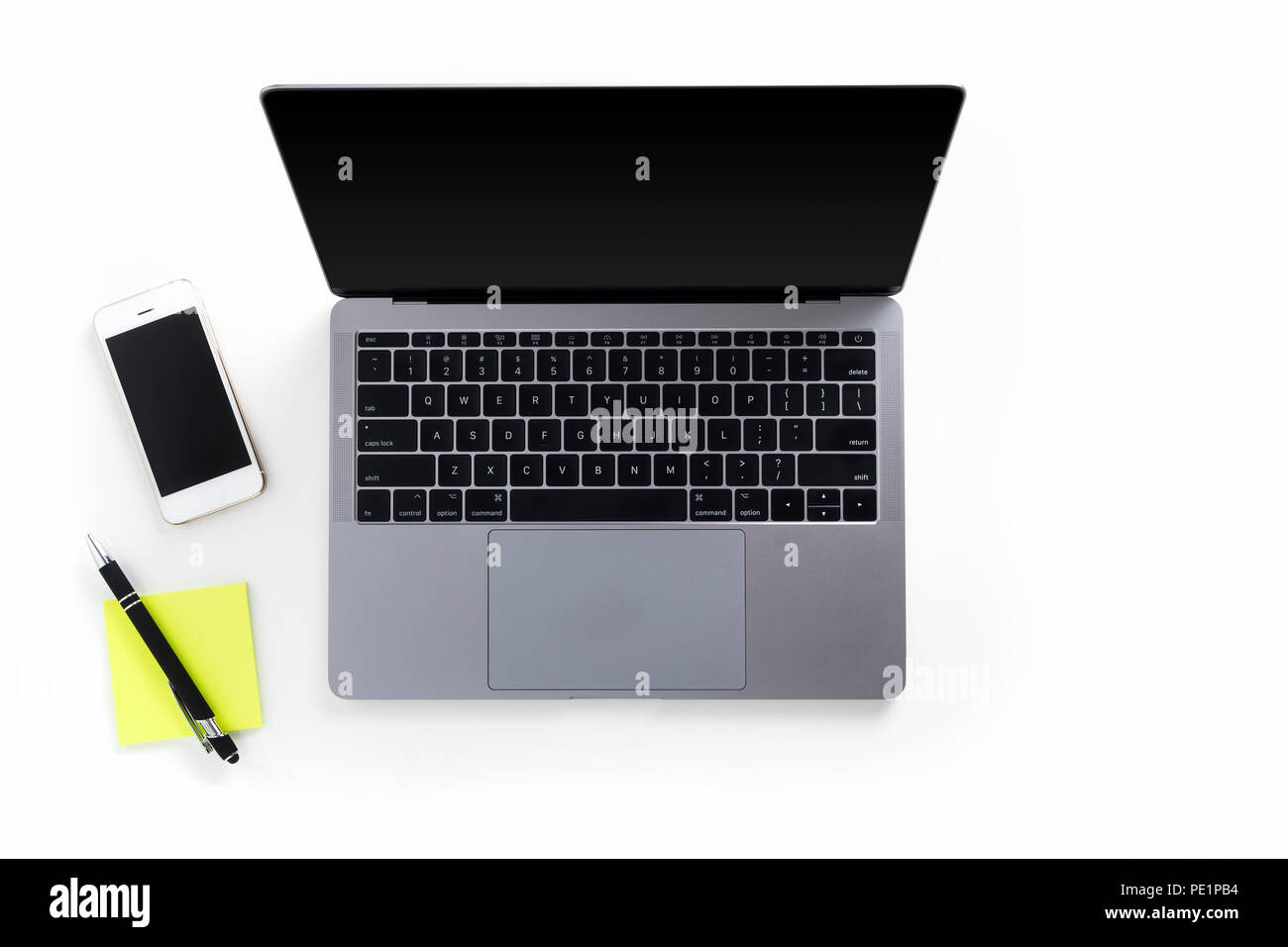 Top view of tabletop with laptop, mobile phone, pen and post it notes ...