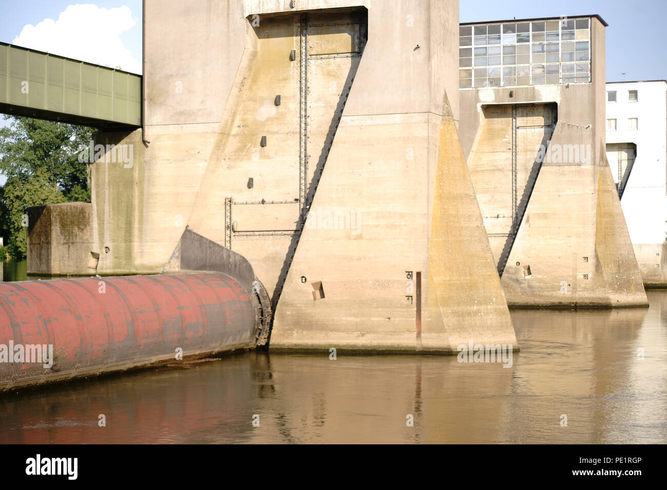 A closed river lock with dormant river water and industrial buildings ...