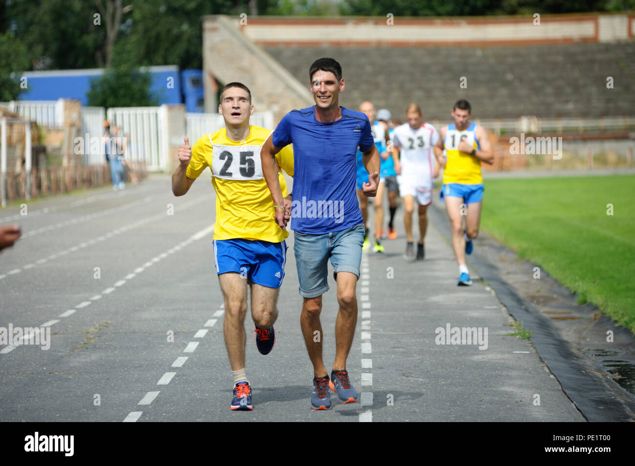 Runner leading blind athlete by strapped hands. Trials among disabled ...