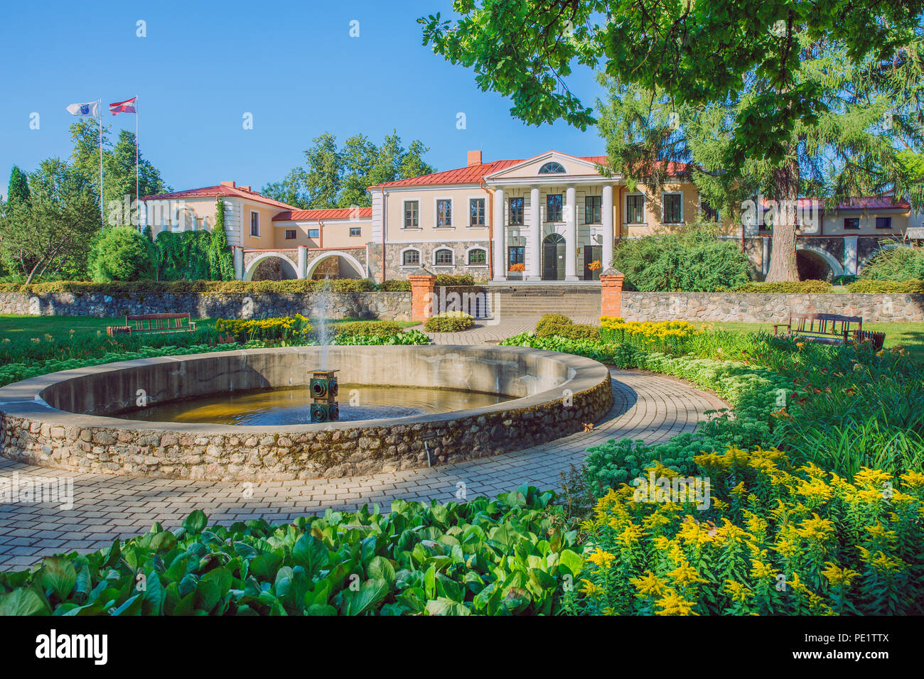 City Vecpiebalga, Latvia. Old manor house and meadow, green trees ...