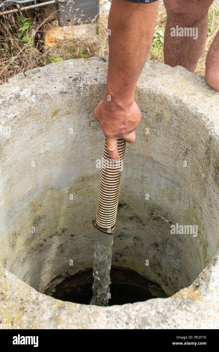 The man fills the earth pit with water Stock Photo - Alamy