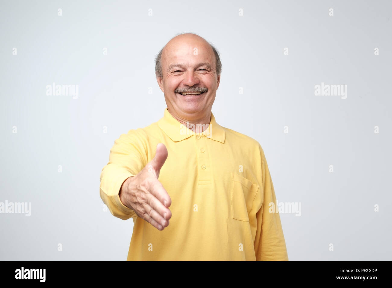 You are welcome concept. Cheerful mature man in yellow t-shirt shirt ...