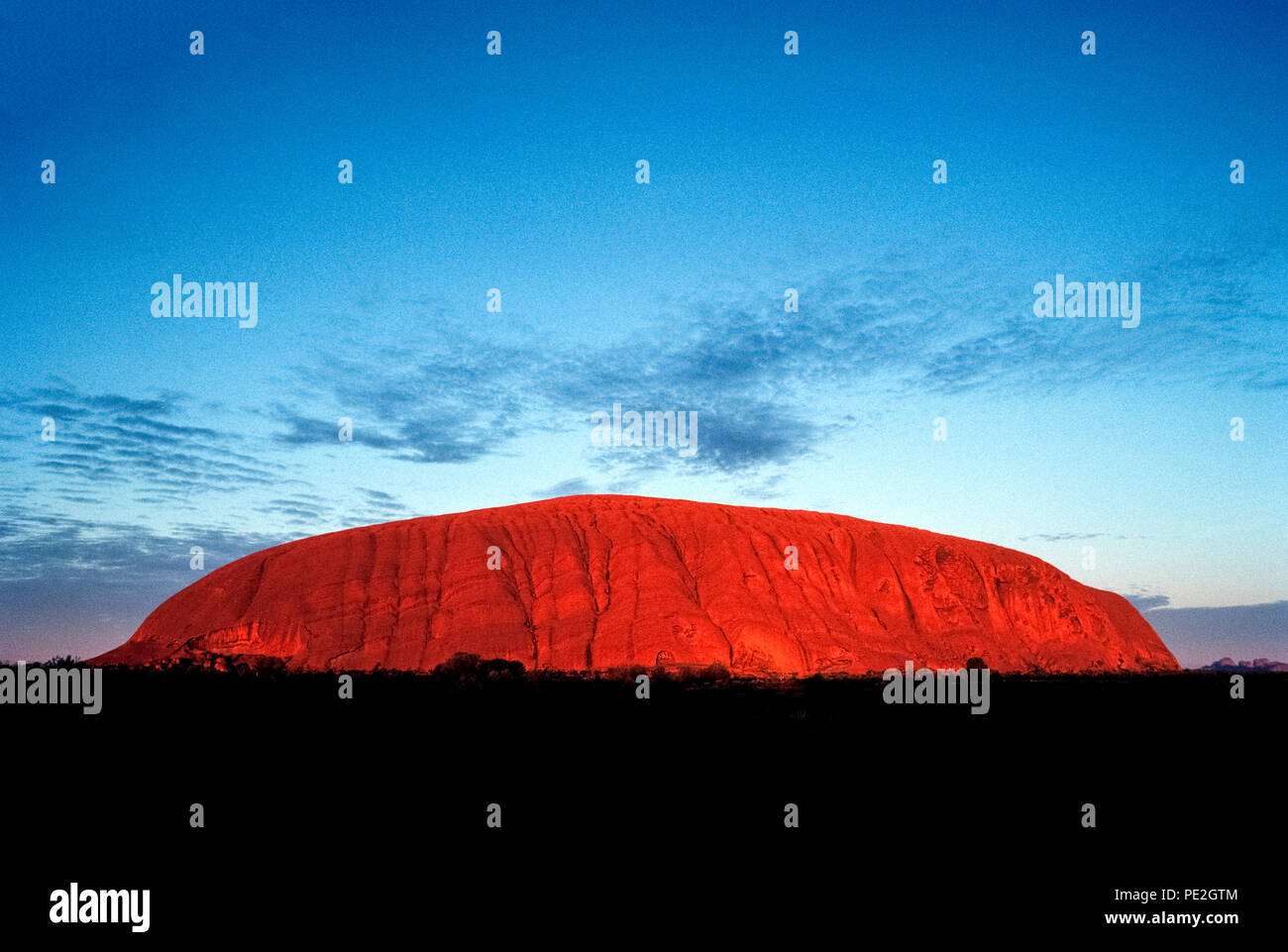 Sunrise on Uluru causes the terracotta-colored surface of this world ...