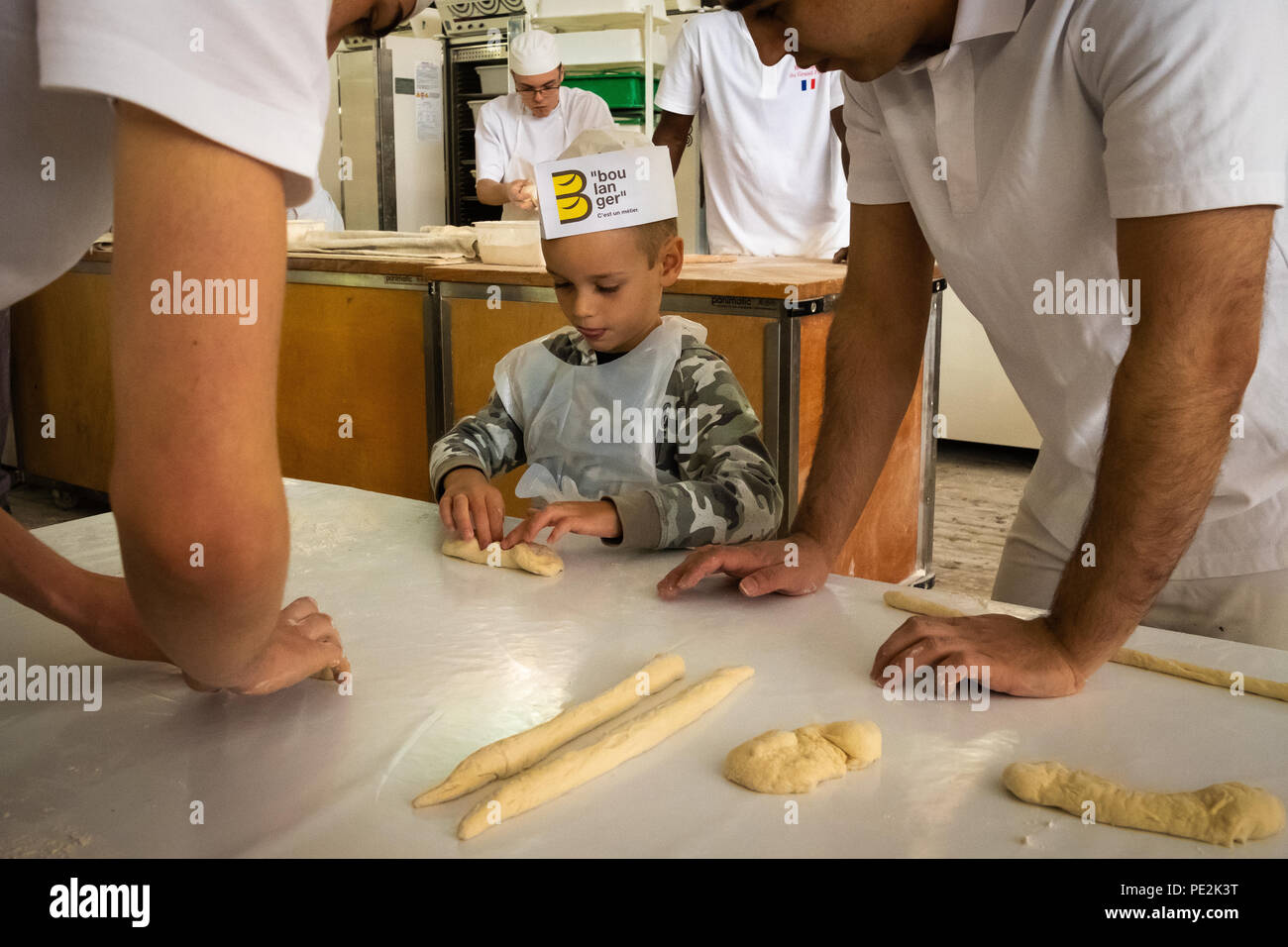 A young boy being taught the fine art of bread-making during La Fete du ...