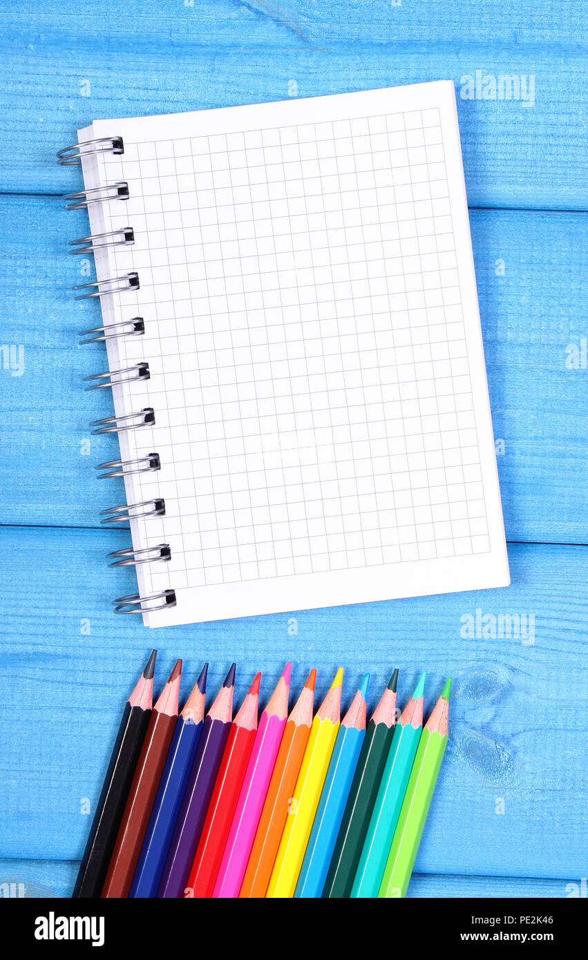 Crayons and notepad for notes on blue boards, school supplies and ...