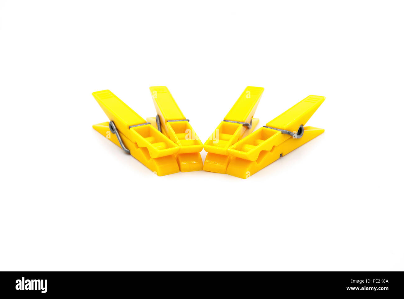 Four yellow pegs on white background Stock Photo - Alamy