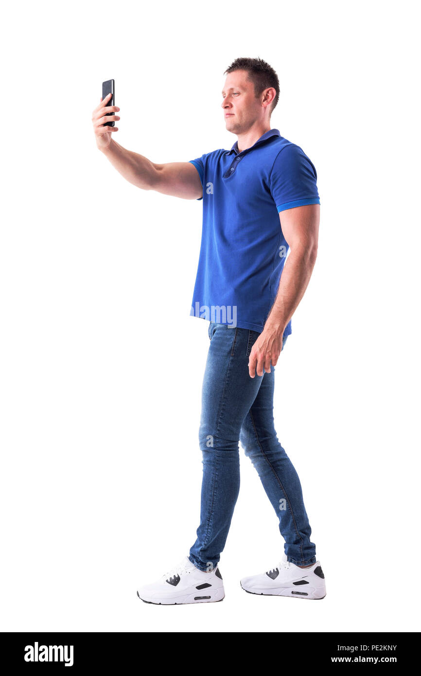 Confident young muscular casual man taking picture with mobile phone ...