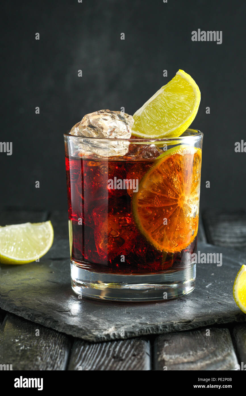 Rum and cola cocktail on dark background Stock Photo - Alamy