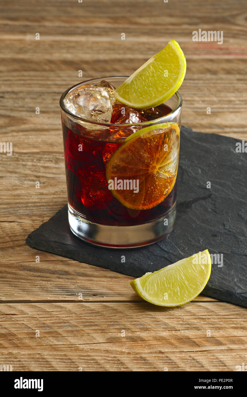Rum and cola cocktail on wooden background Stock Photo - Alamy