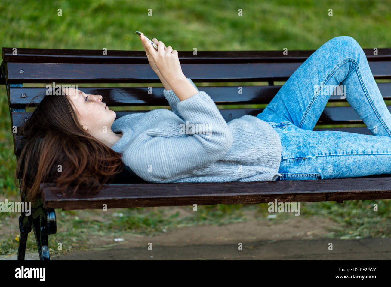 Girl lying on bench reading hi-res stock photography and images - Alamy