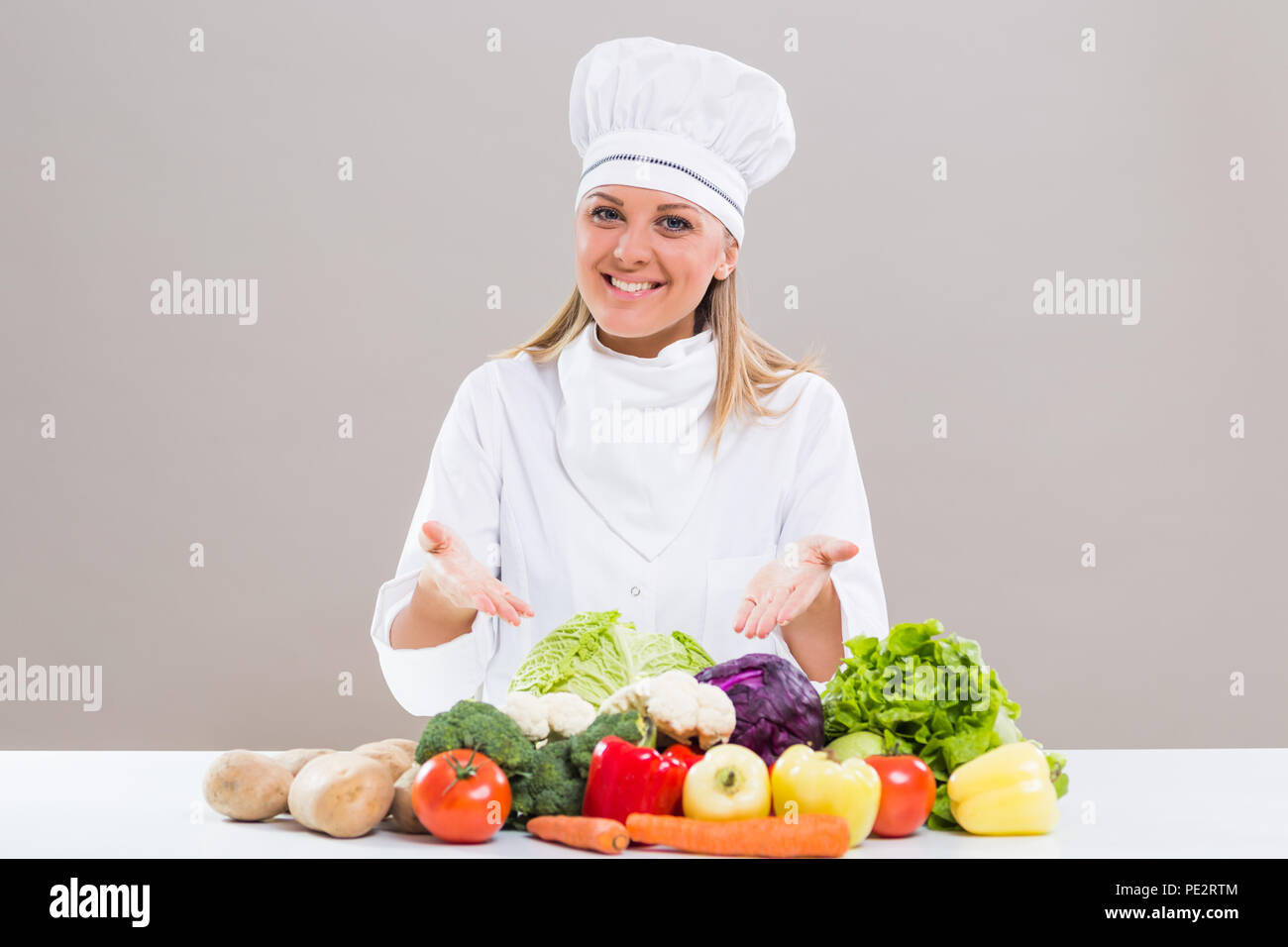 Beautiful chef showing bunch of vegetable Stock Photo - Alamy
