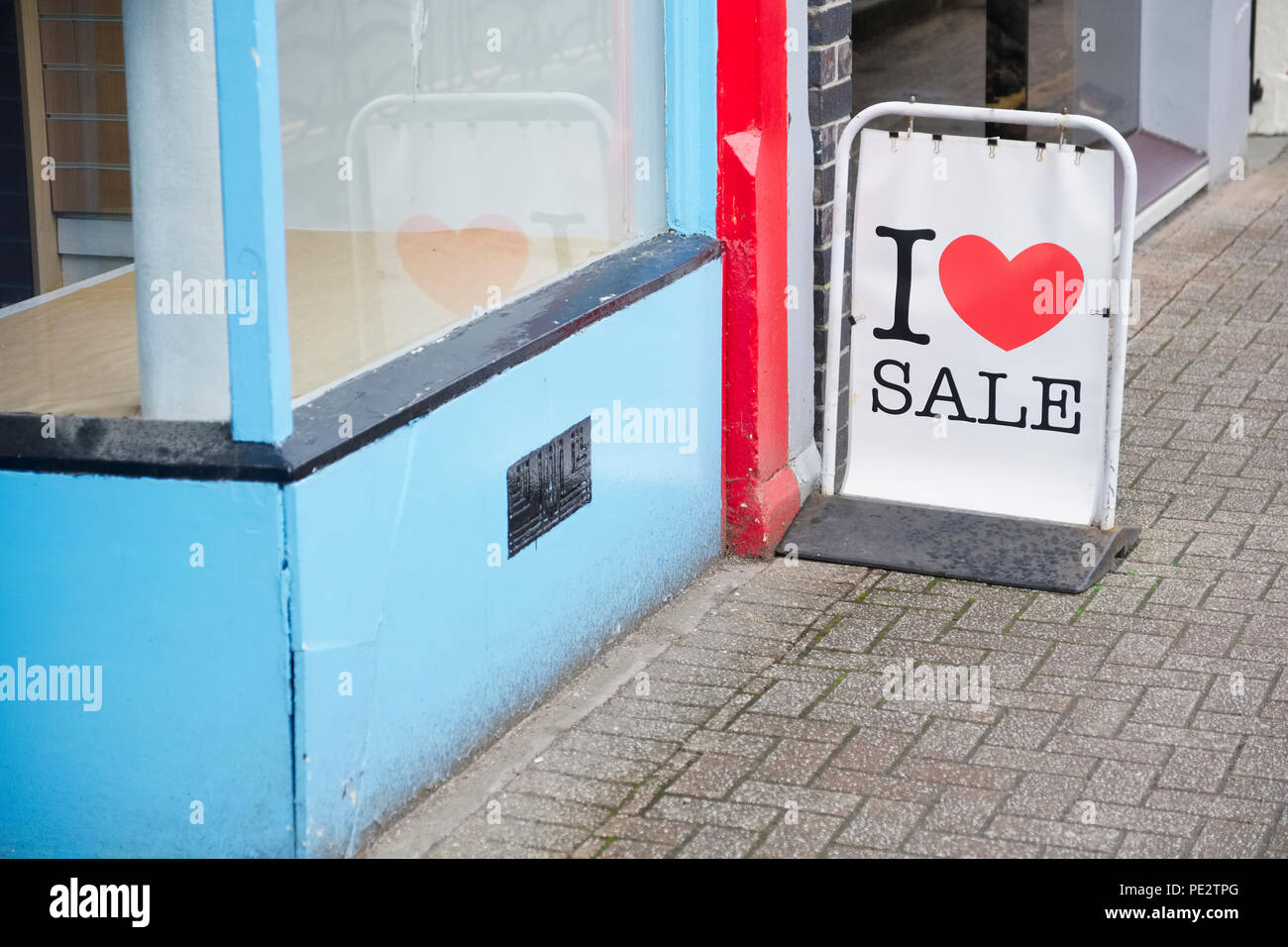 I love sale sign board on street pavement outside shop with love heart ...