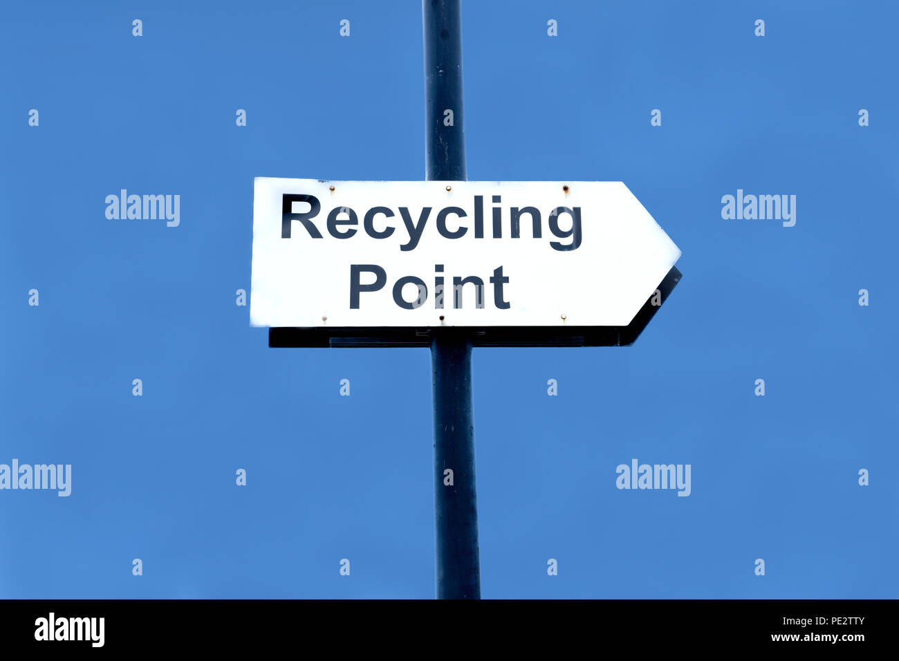 Recycling point direction sign against blue blank sky Stock Photo - Alamy