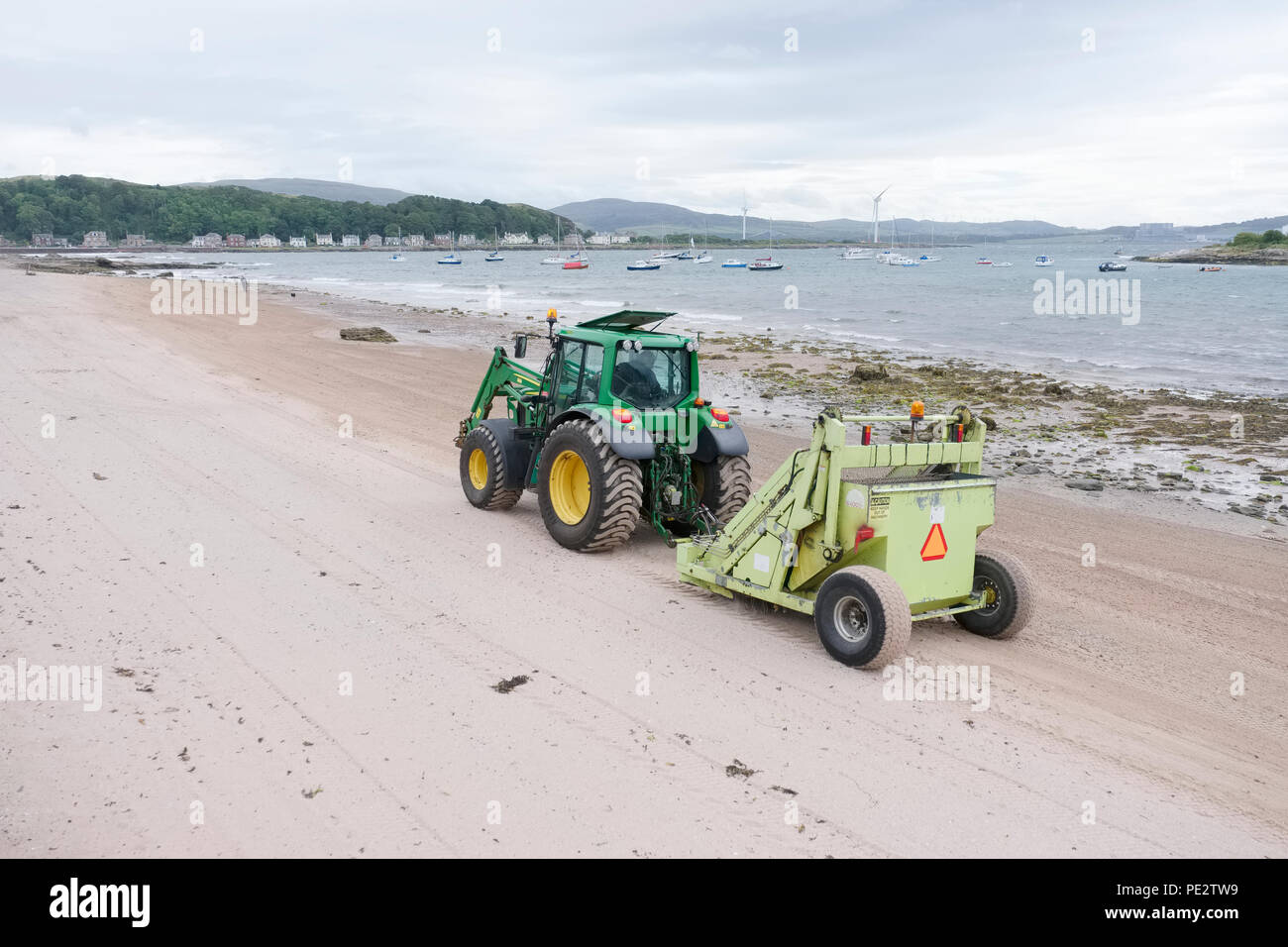 Tractor on sandy beach cleaning up rubbish and litter to help clean the ...